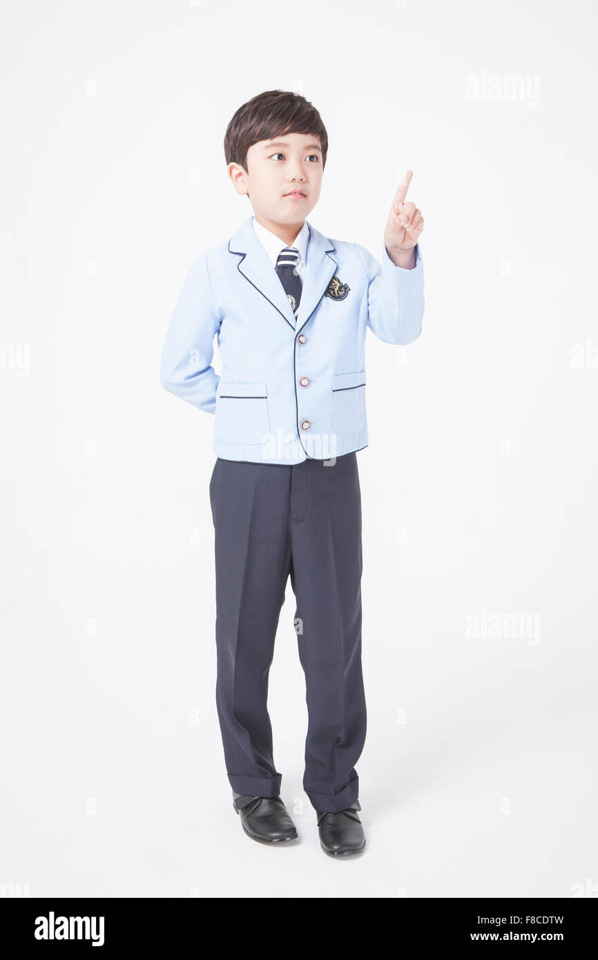 Elementary school boy in school uniforms standing and pointing up with ...