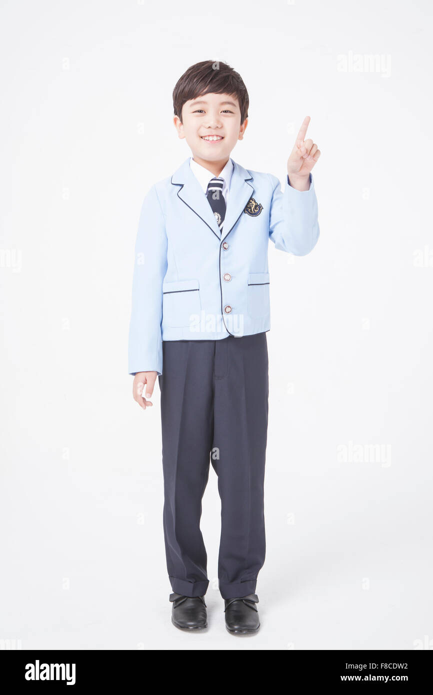Elementary school boy in school uniforms standing and pointing up with ...