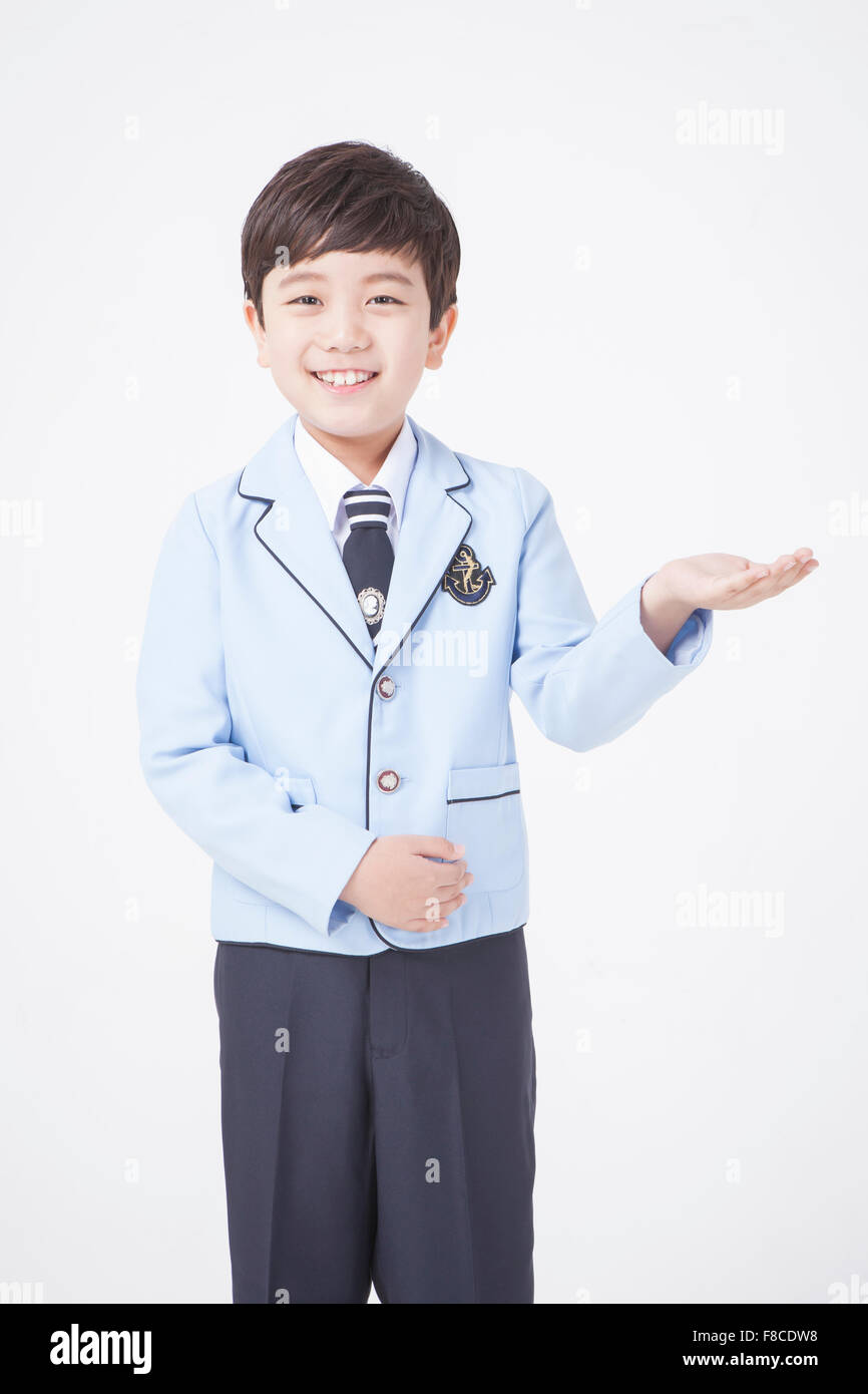 Elementary school boy in school uniforms with a hand gesture of putting ...