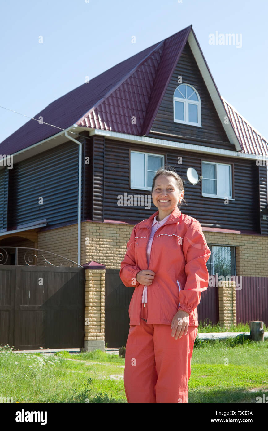 Happy mature woman posing in front of her residence Stock Photo - Alamy