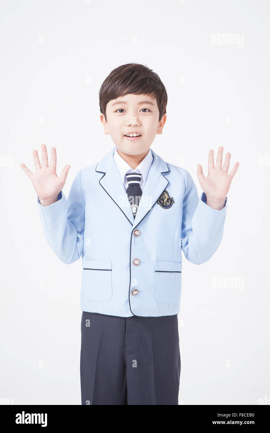 Elementary school boy in school uniforms staring forward and showing ...