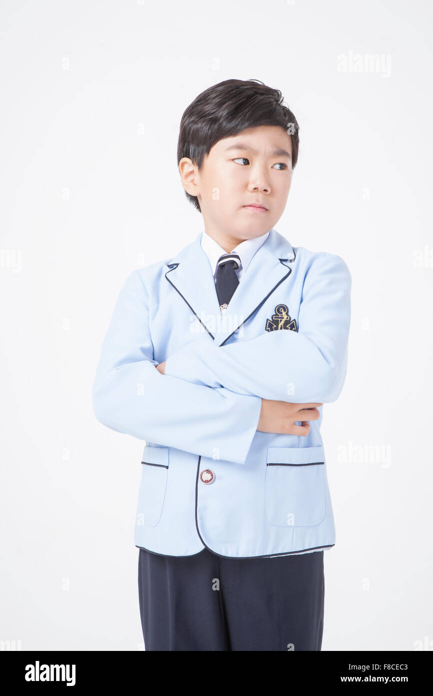 Elementary school boy in school uniforms frowning his face with his ...