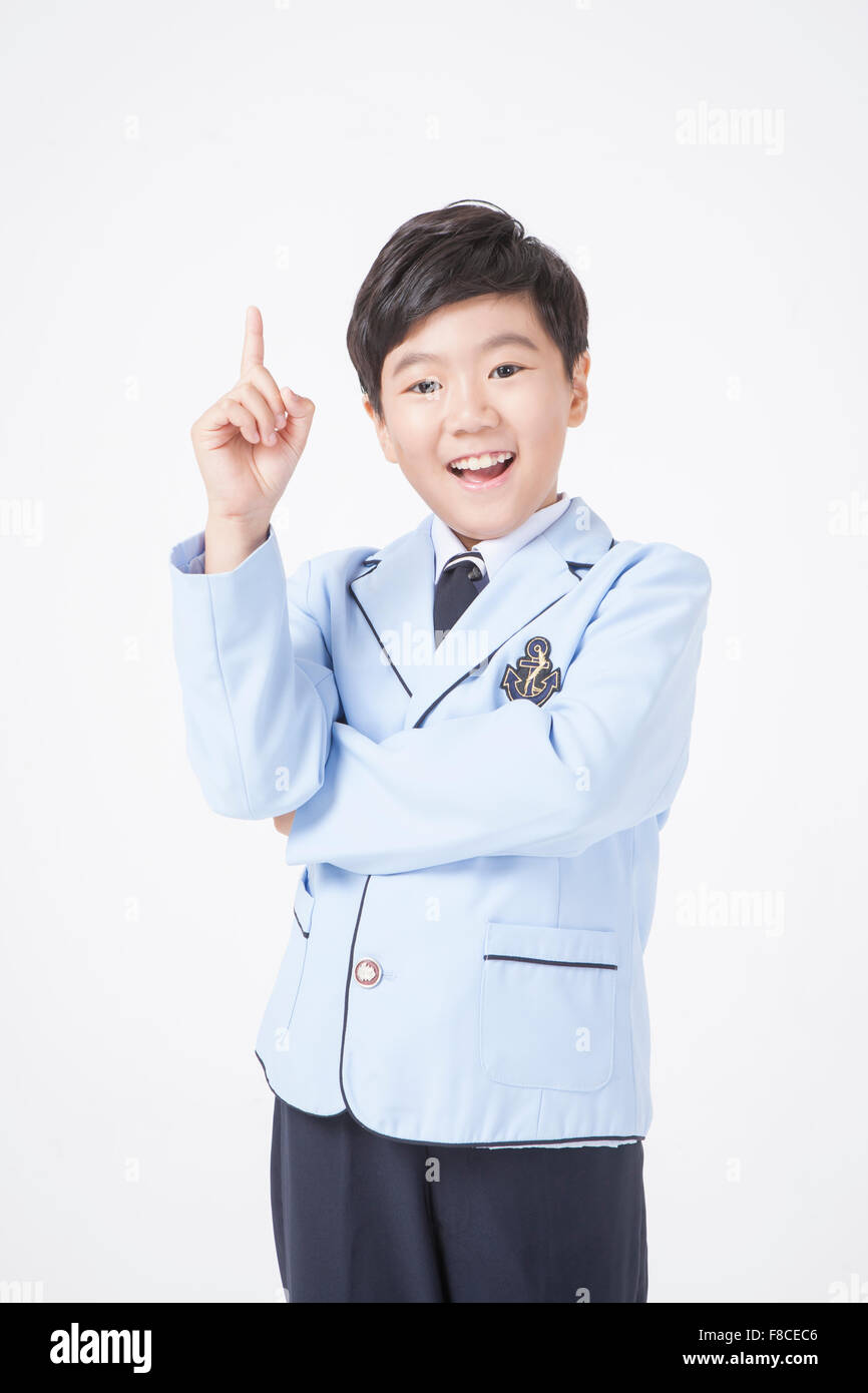 Elementary school boy in school uniforms smiling and pointing up with ...