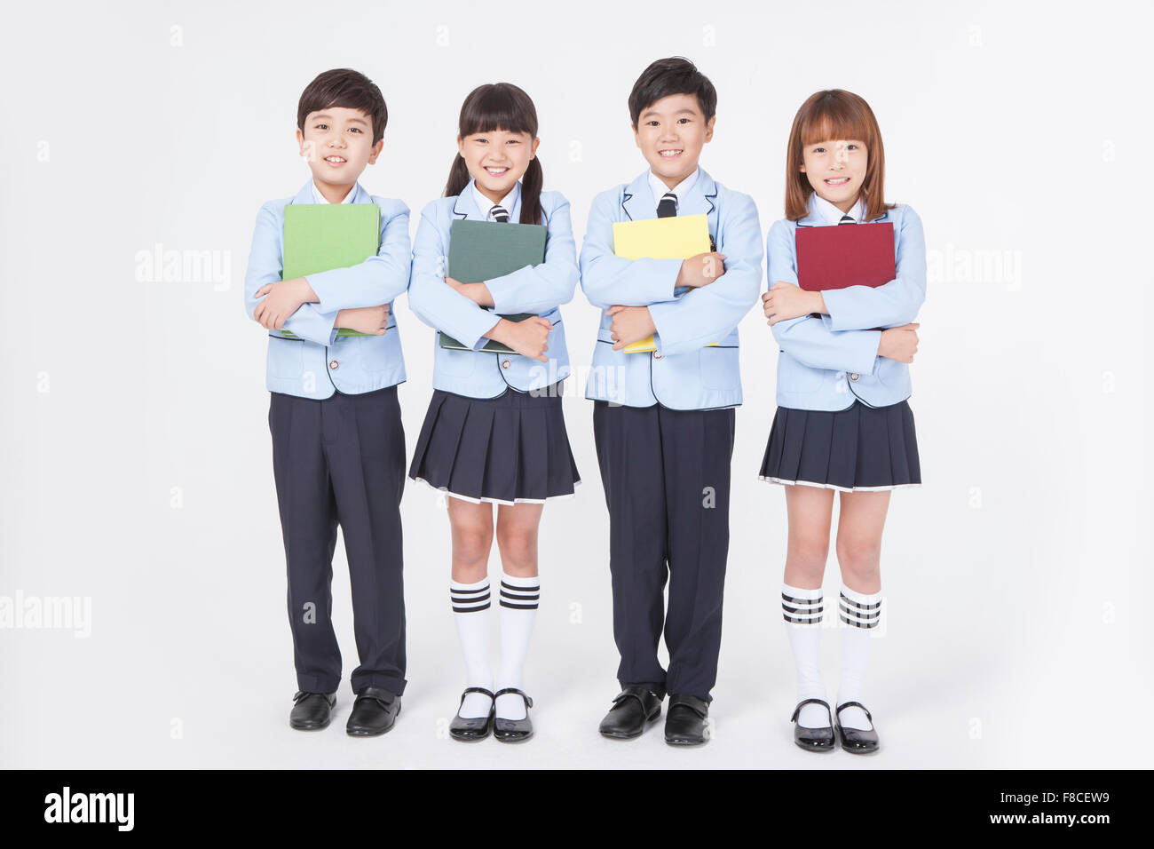 Four elementary school students in school uniforms standing and holding ...