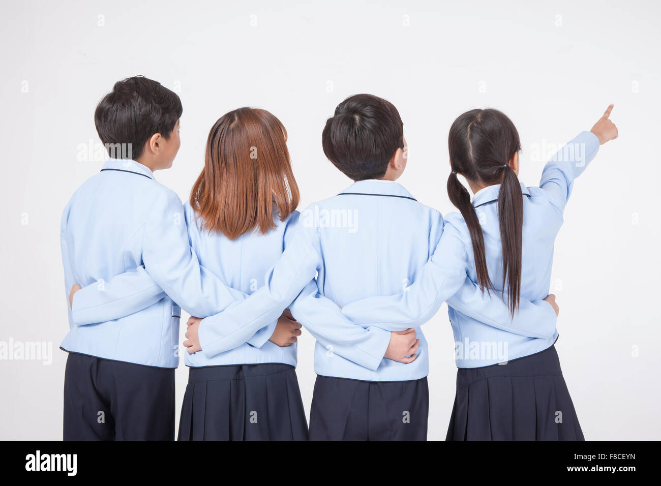 Back appearance of four elementary school students in school uniforms ...