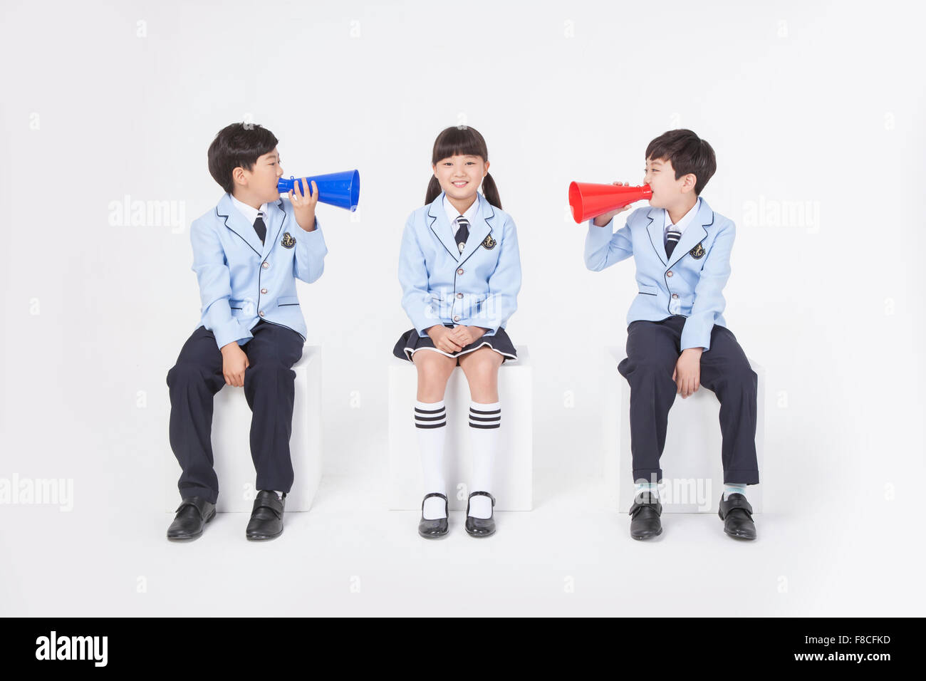 Two elementary school boys in school uniforms speaking through a ...