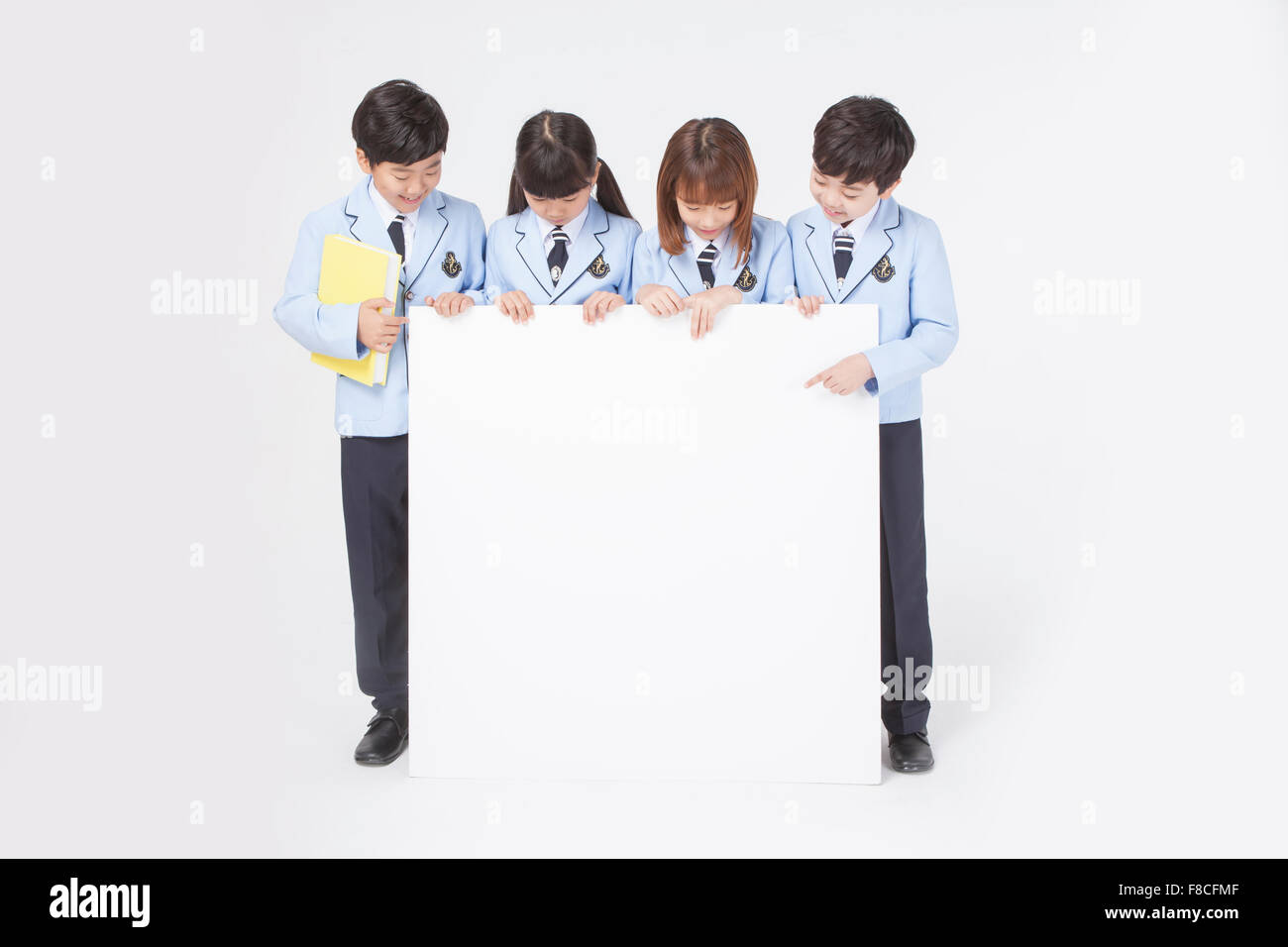 White copy space and four elementary school students in school uniforms ...