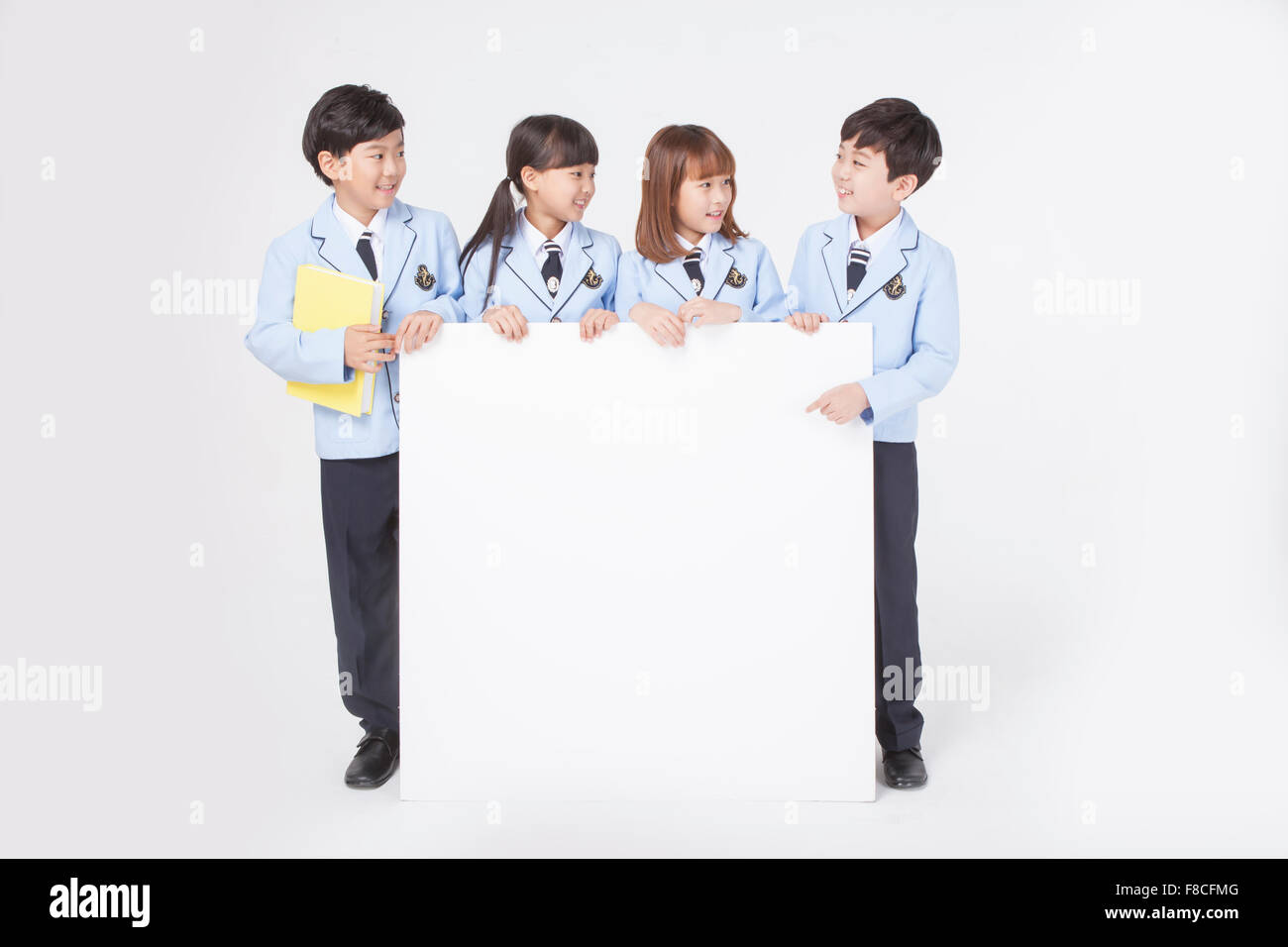 White copy space and four elementary school students in school uniforms ...
