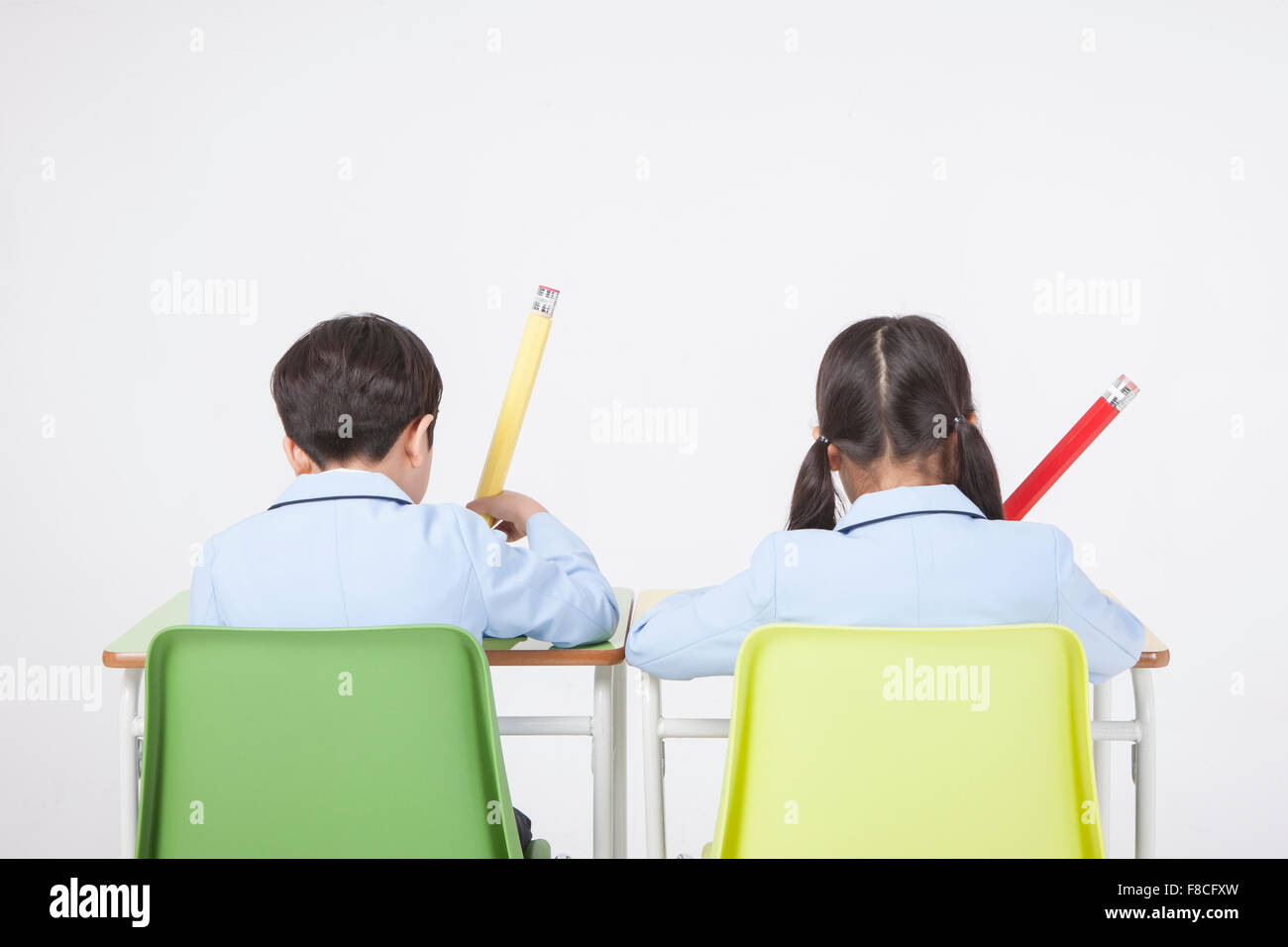 Back appearance of elementary school boy and girl in school uniforms ...