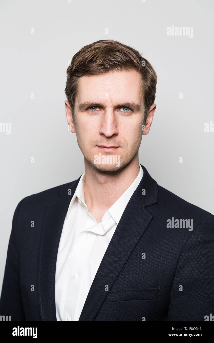 Blond-haired european businessman with a stern look stares into the ...