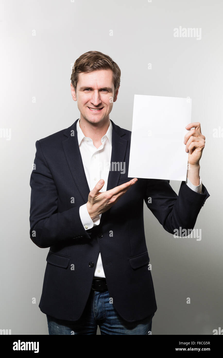 Blond-haired european businessman shows something on a pice of paper ...