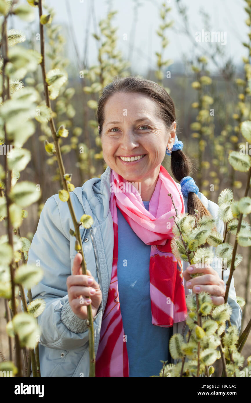 portrait of happy mature woman against spring Willow branches with buds ...