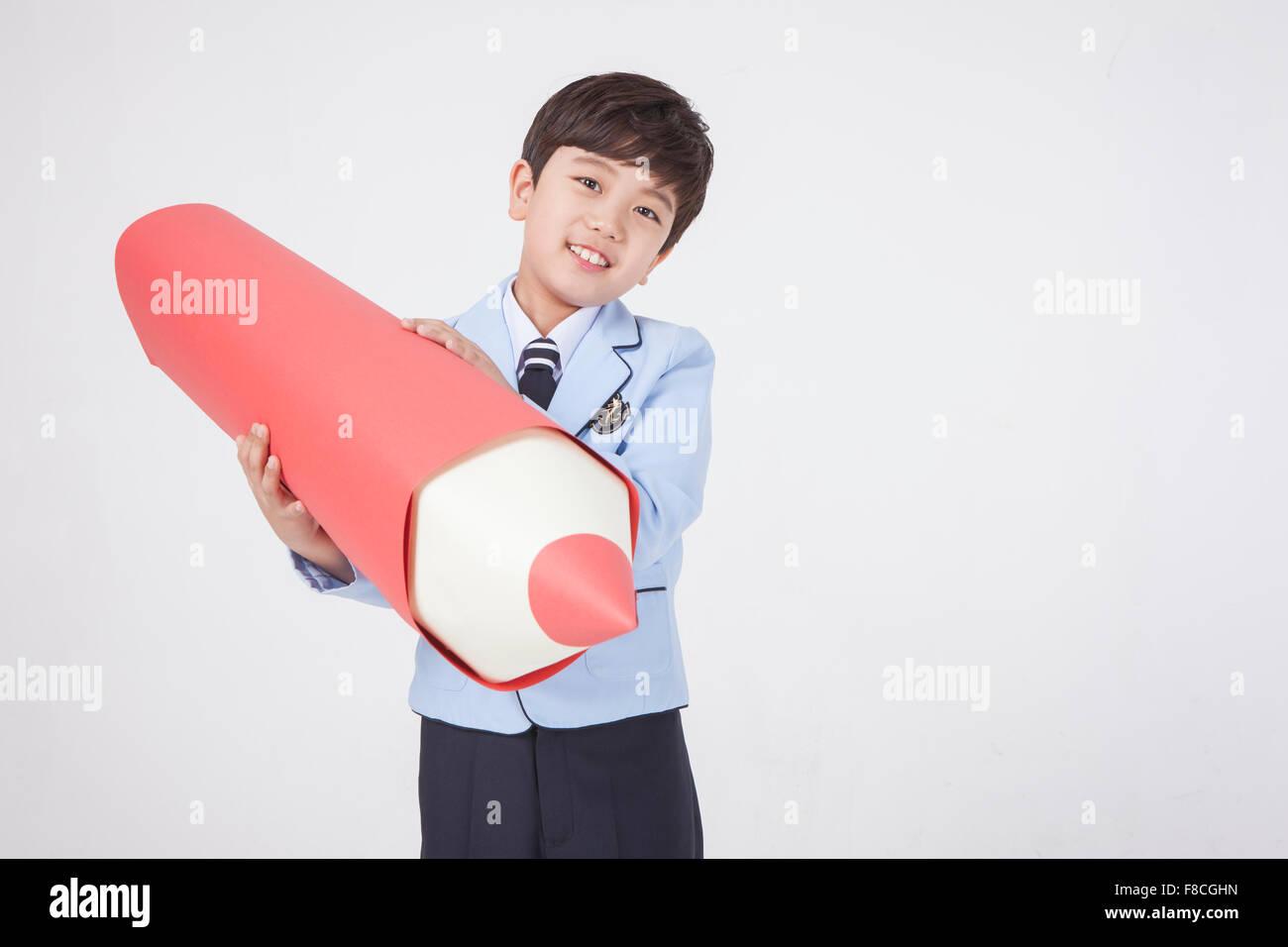 Elementary school boy in school uniforms holding a big red pencil Stock ...