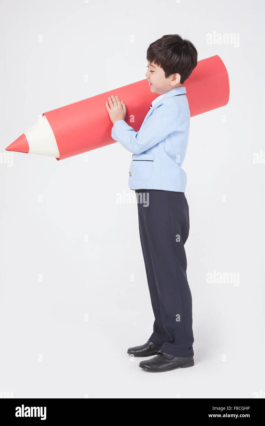 Elementary school boy in school uniforms standing sideways and holding ...