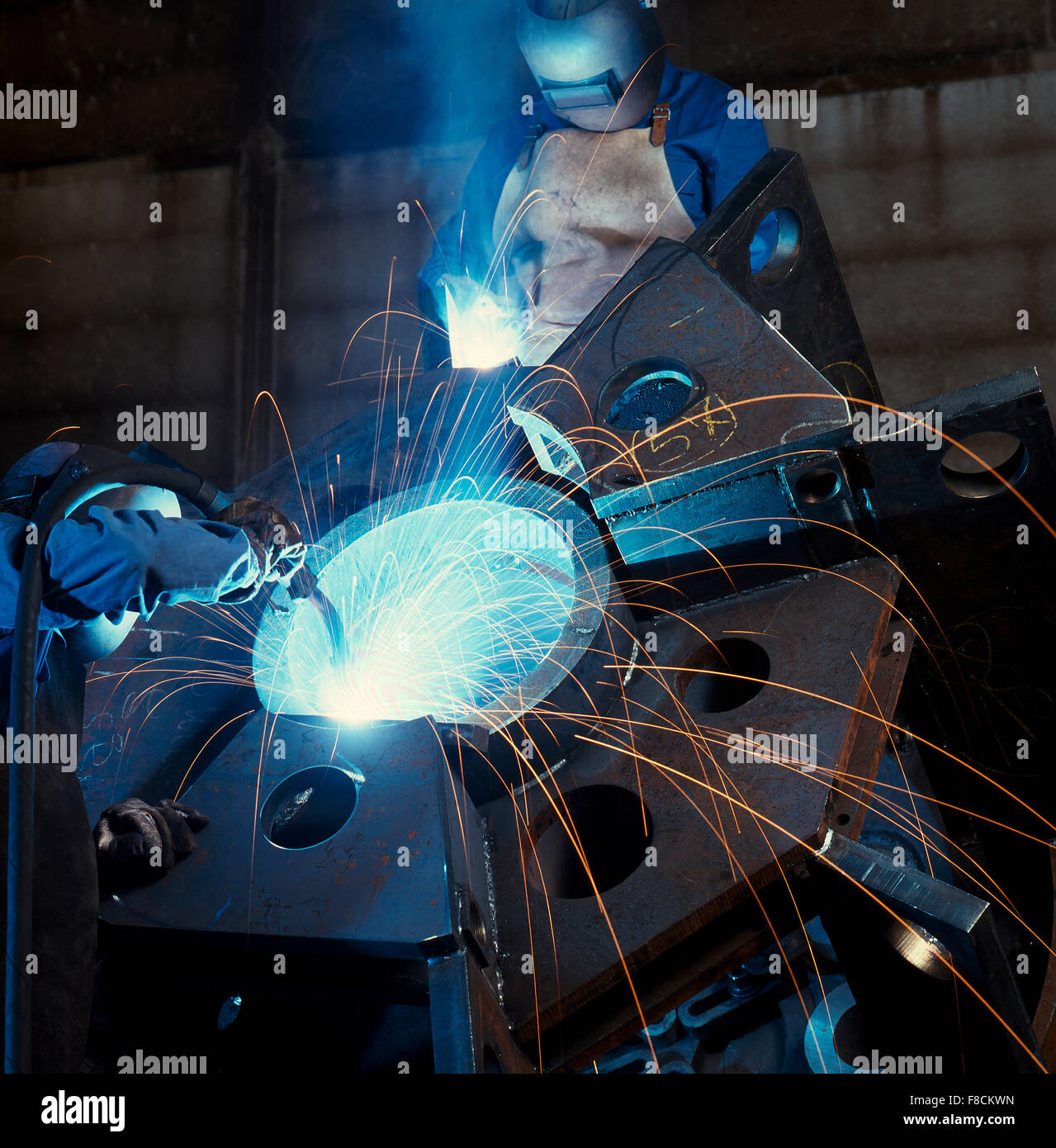 welding specialists welding a big piece of metal Stock Photo - Alamy