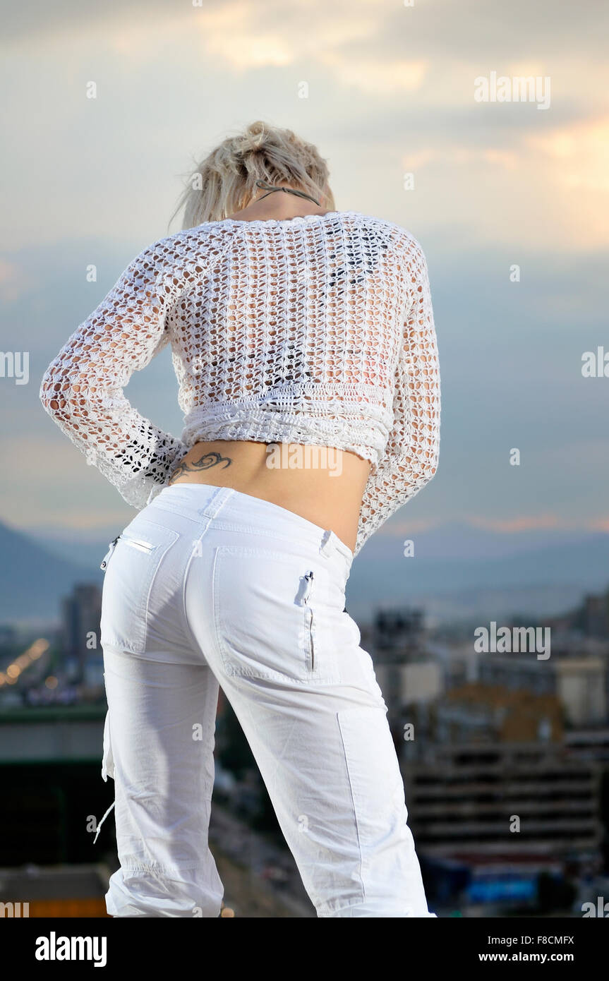 young gogo dancer girl on top of the building with city in backgound ...