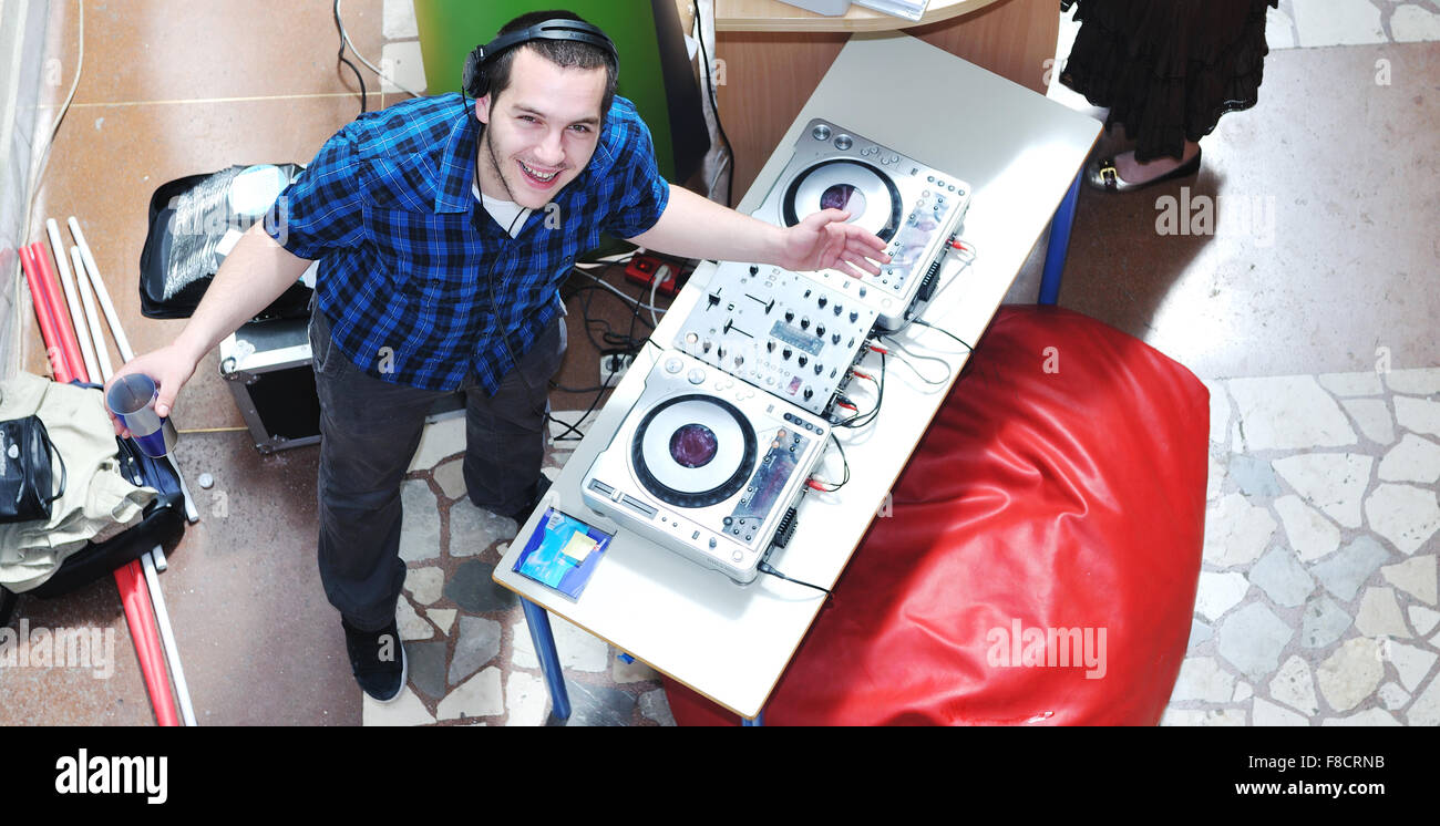 young dj man with headphones and compact disc dj equipment on party ...