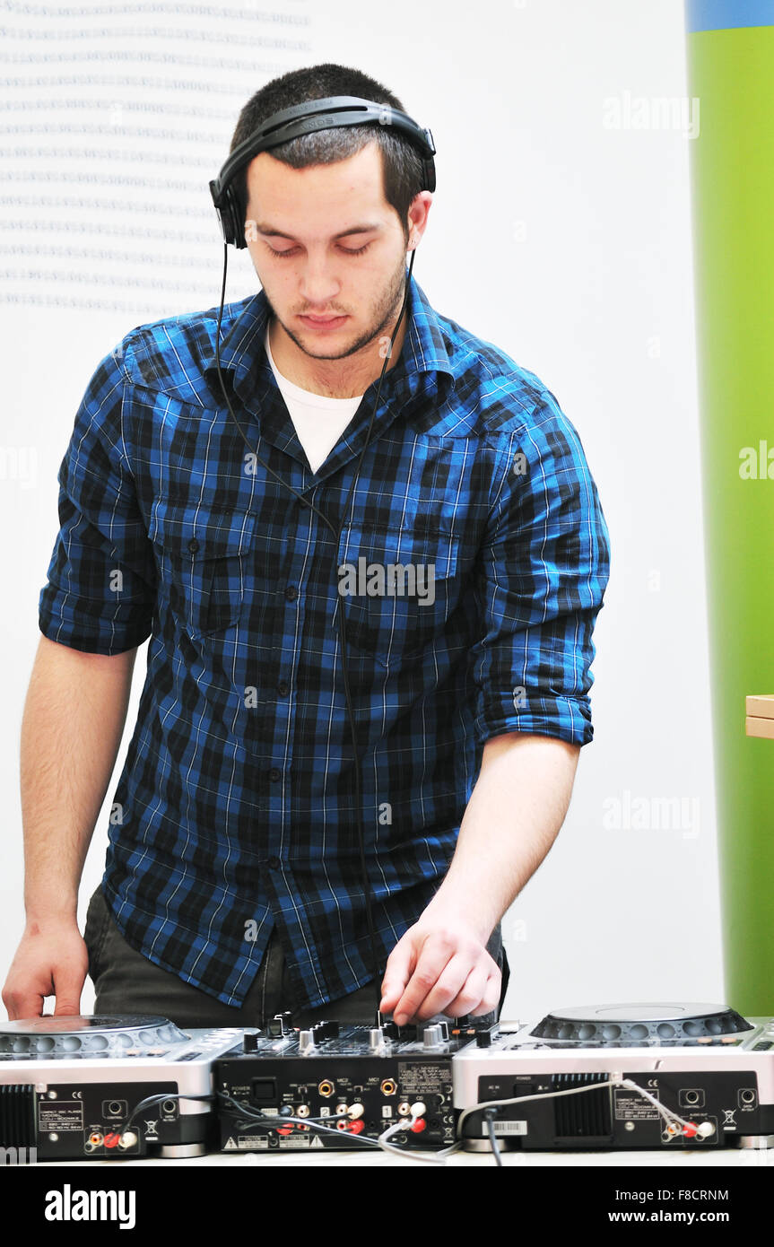 young dj man with headphones and compact disc dj equipment on party ...