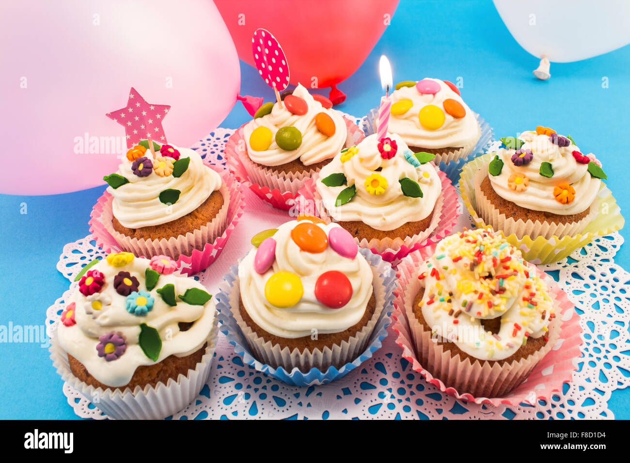 Birthday cupcakes with balloons on a blue background Stock Photo - Alamy