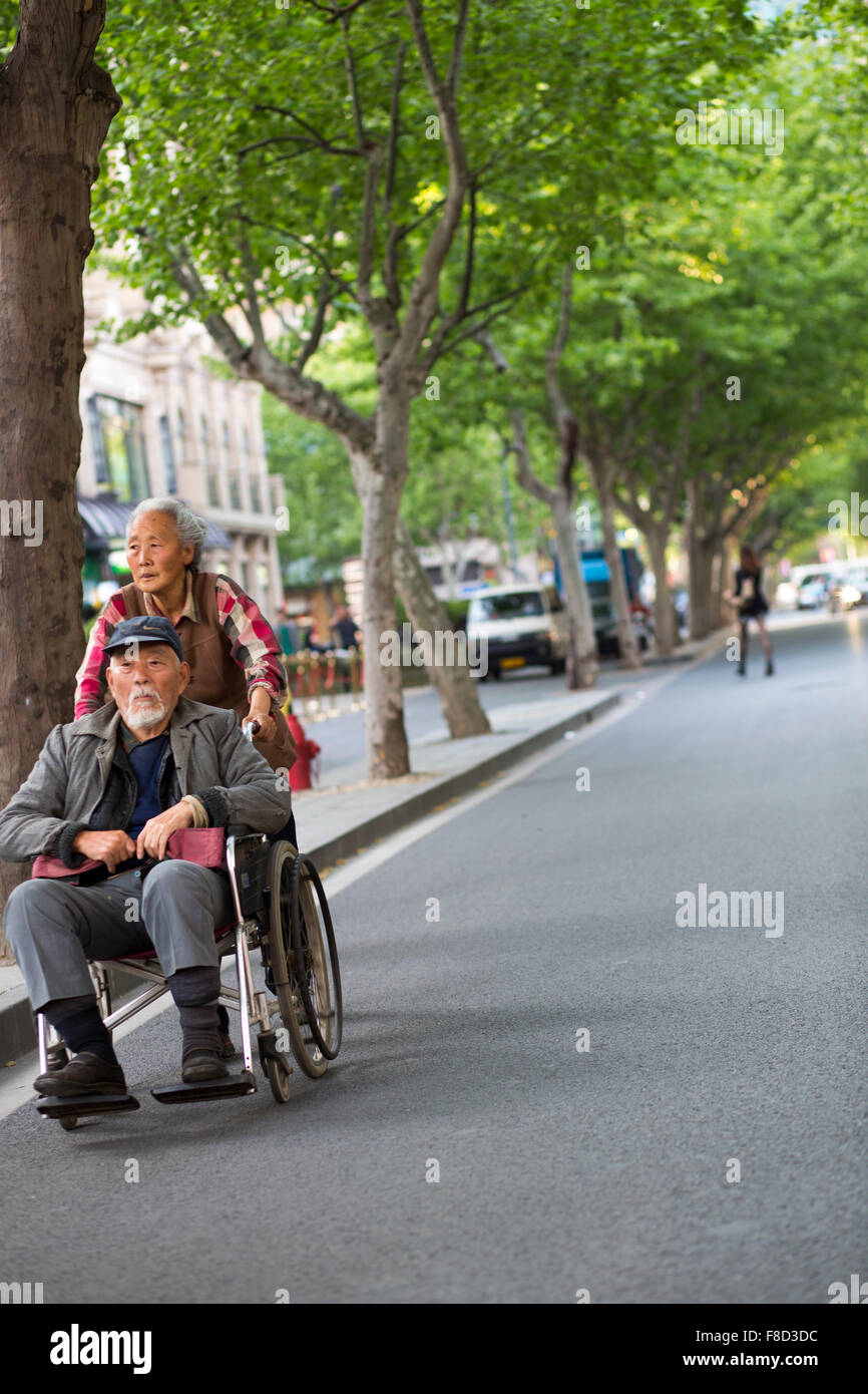 Mature man pushing elderly woman in wheelchair hi-res stock photography ...