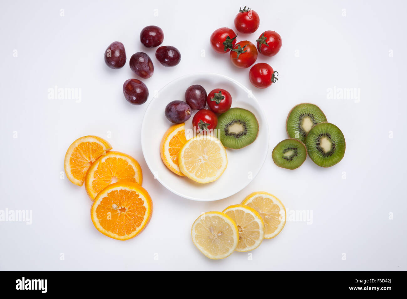 High angle of fresh slices of fruits including orange, lemon, kiwi, and ...