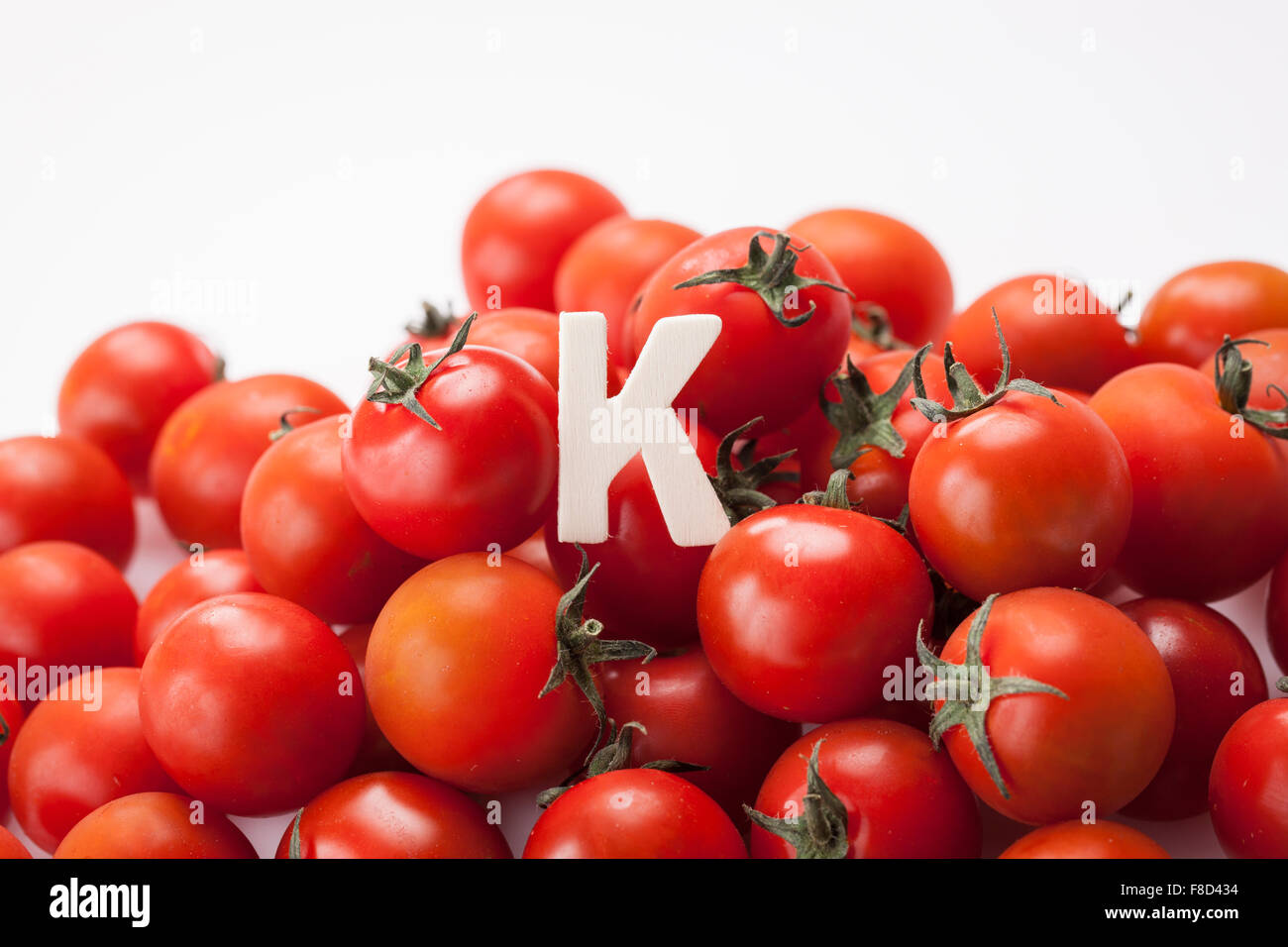 Stack of cherry tomatoes and an alphabet K in the middle of them Stock ...