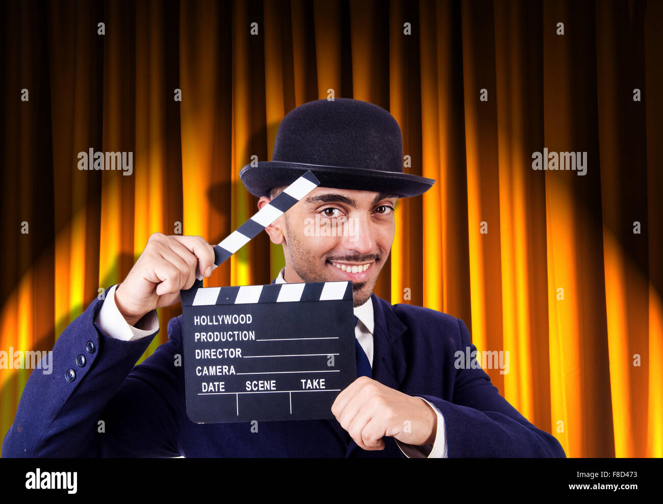 Man with movie clapper on curtain background Stock Photo - Alamy