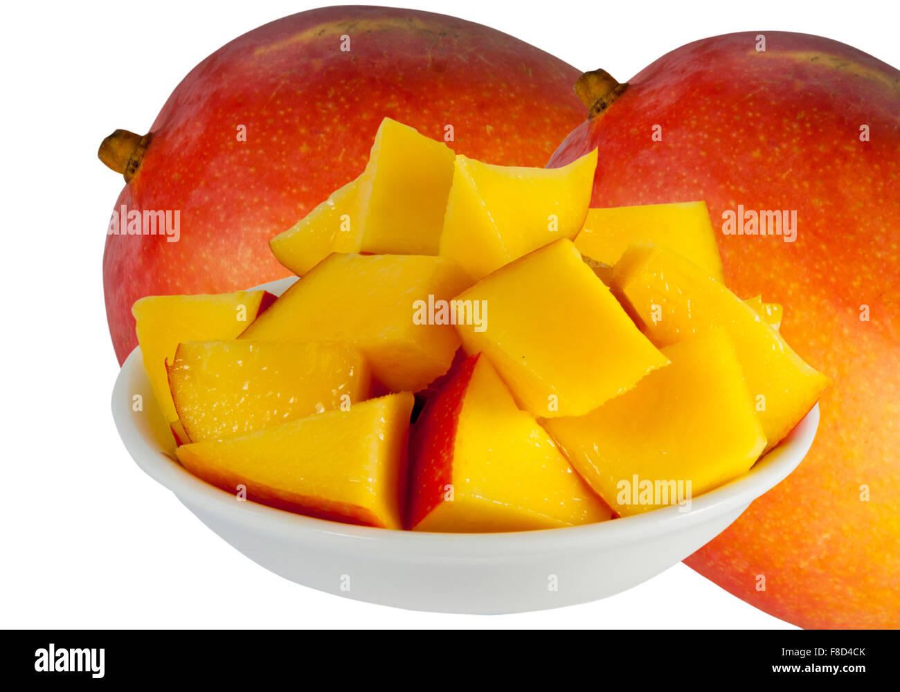 two whole mango and cubed mango on a plate with white background Stock ...