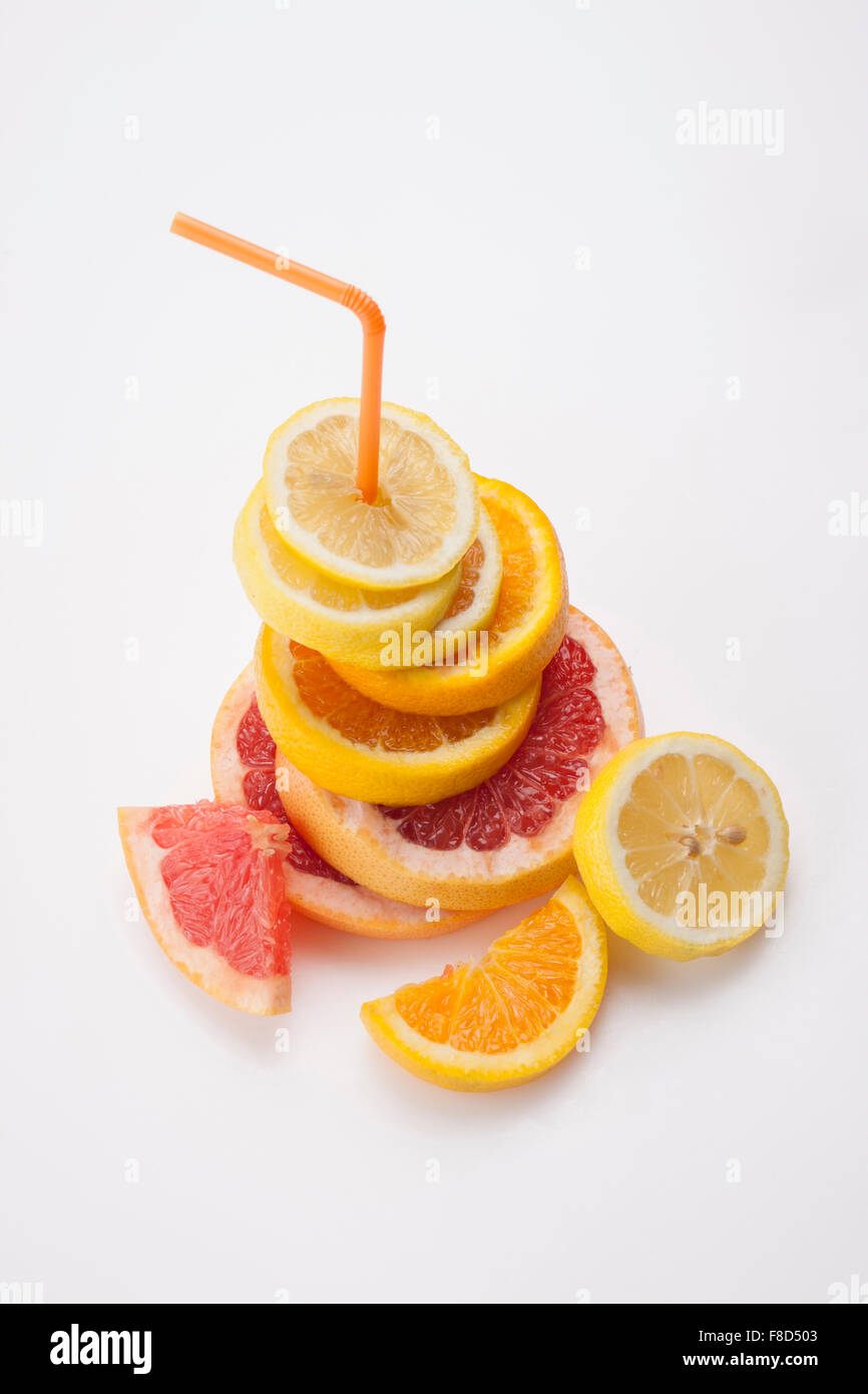 High angle of a straw stuck in a pile of orange, lemon, grapefruit ...