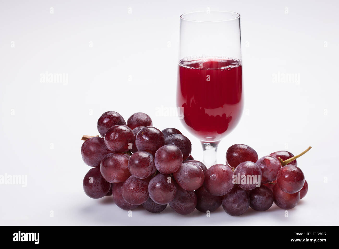 Glass of red grape juice with fresh red grapes Stock Photo - Alamy
