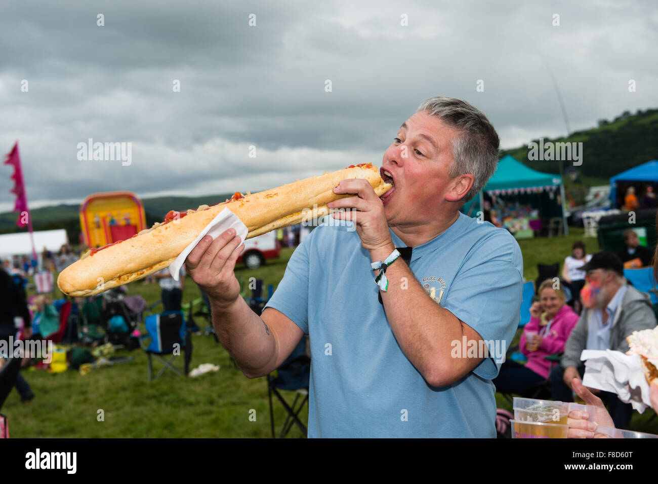 A man eating a giant 2' (two foot) long hot dog at The Big Tribute ...