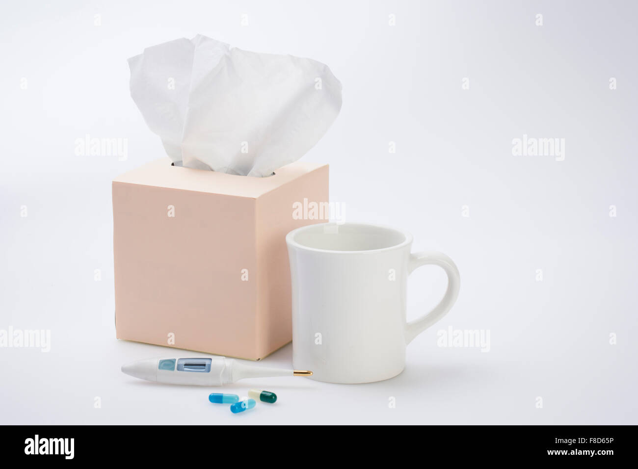 Tissue in a box, a cup, a thermometer, and pills Stock Photo - Alamy