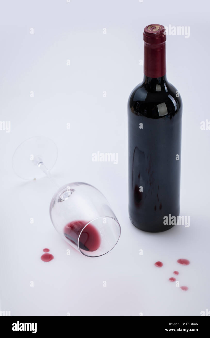 High angle of wine bottle and fallen wine glass with some wine stain ...
