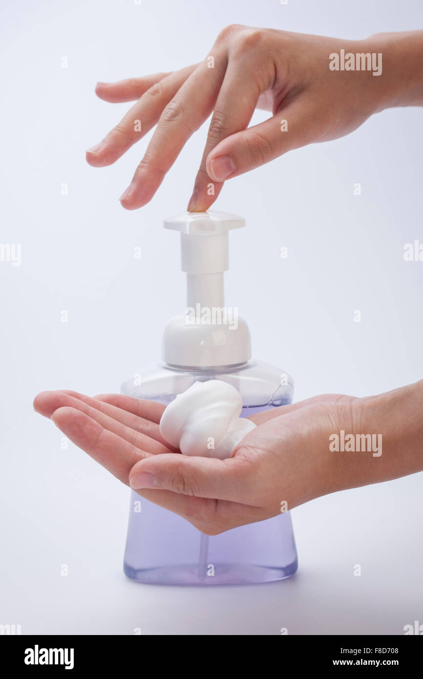 Hand pushing a hand soap and foam on the other hand Stock Photo - Alamy