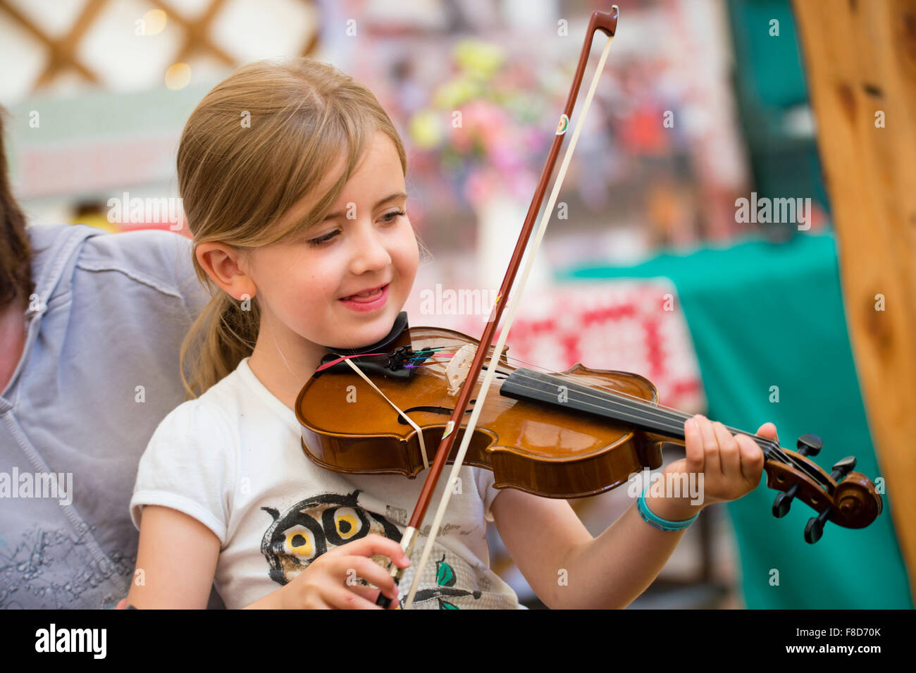 A young girl child playing folk music on a fiddle or violin at The ...