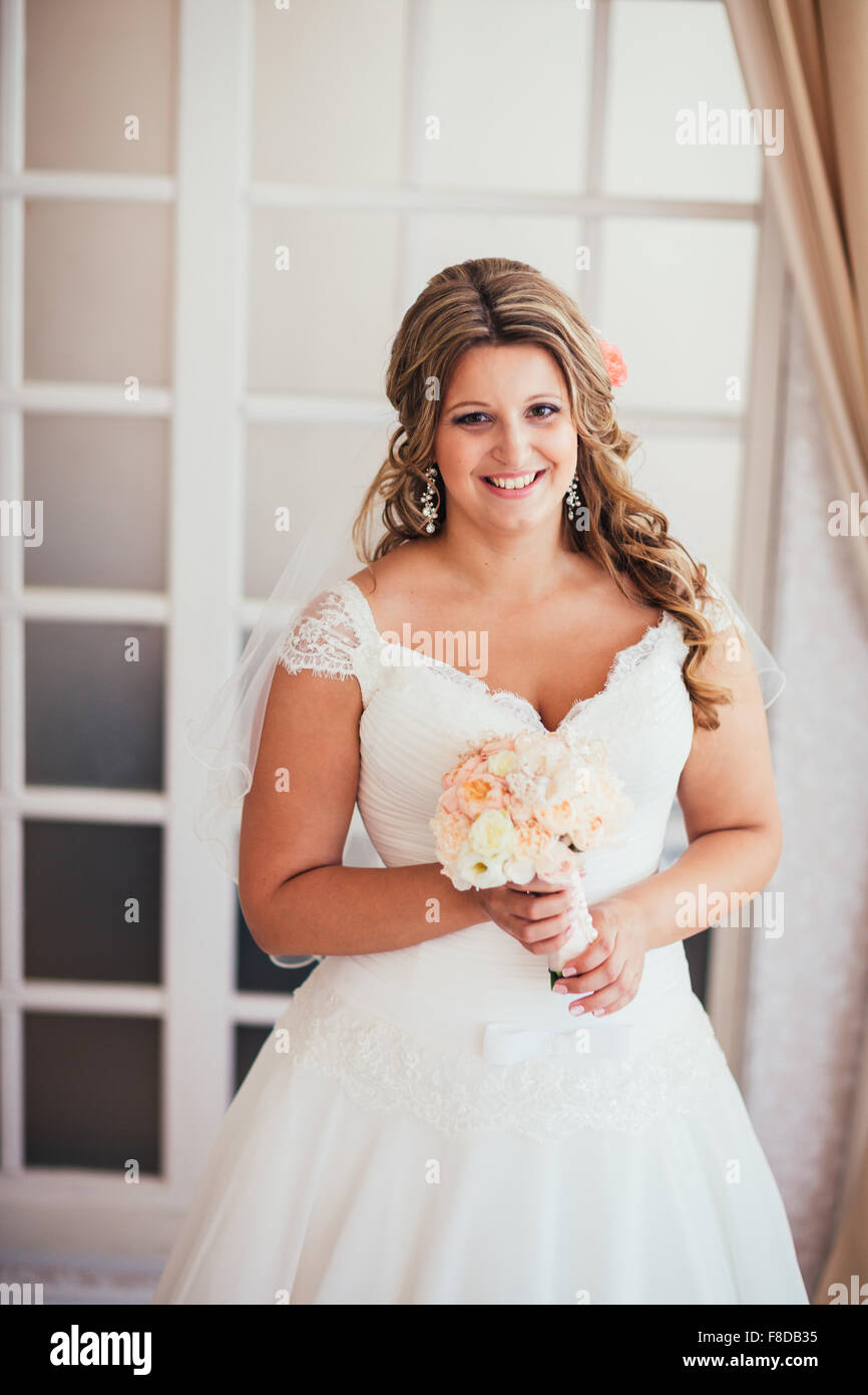 elegance cute bride is posing on the background room Stock Photo - Alamy