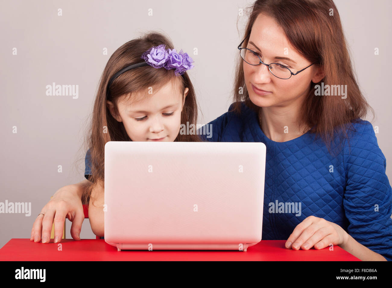 Child and adult work at the computer Stock Photo - Alamy