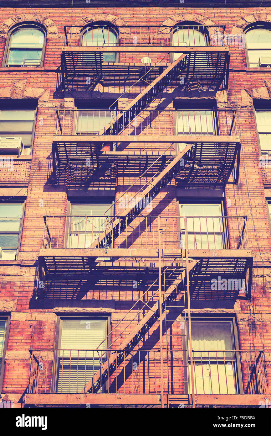 Vintage style photo of New York building with fire escape ladders, USA ...