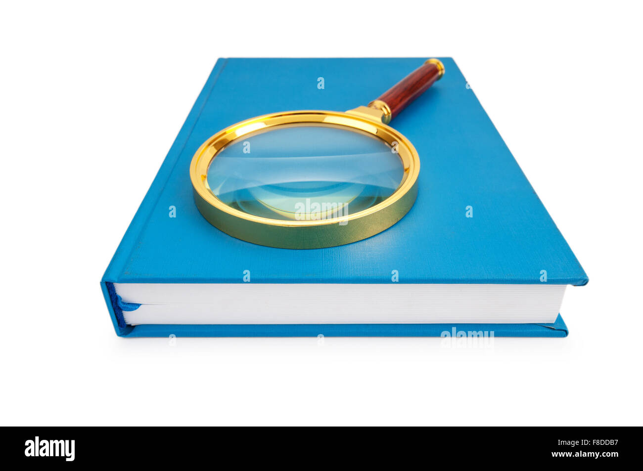 Magnifying glass over the stack of books Stock Photo - Alamy