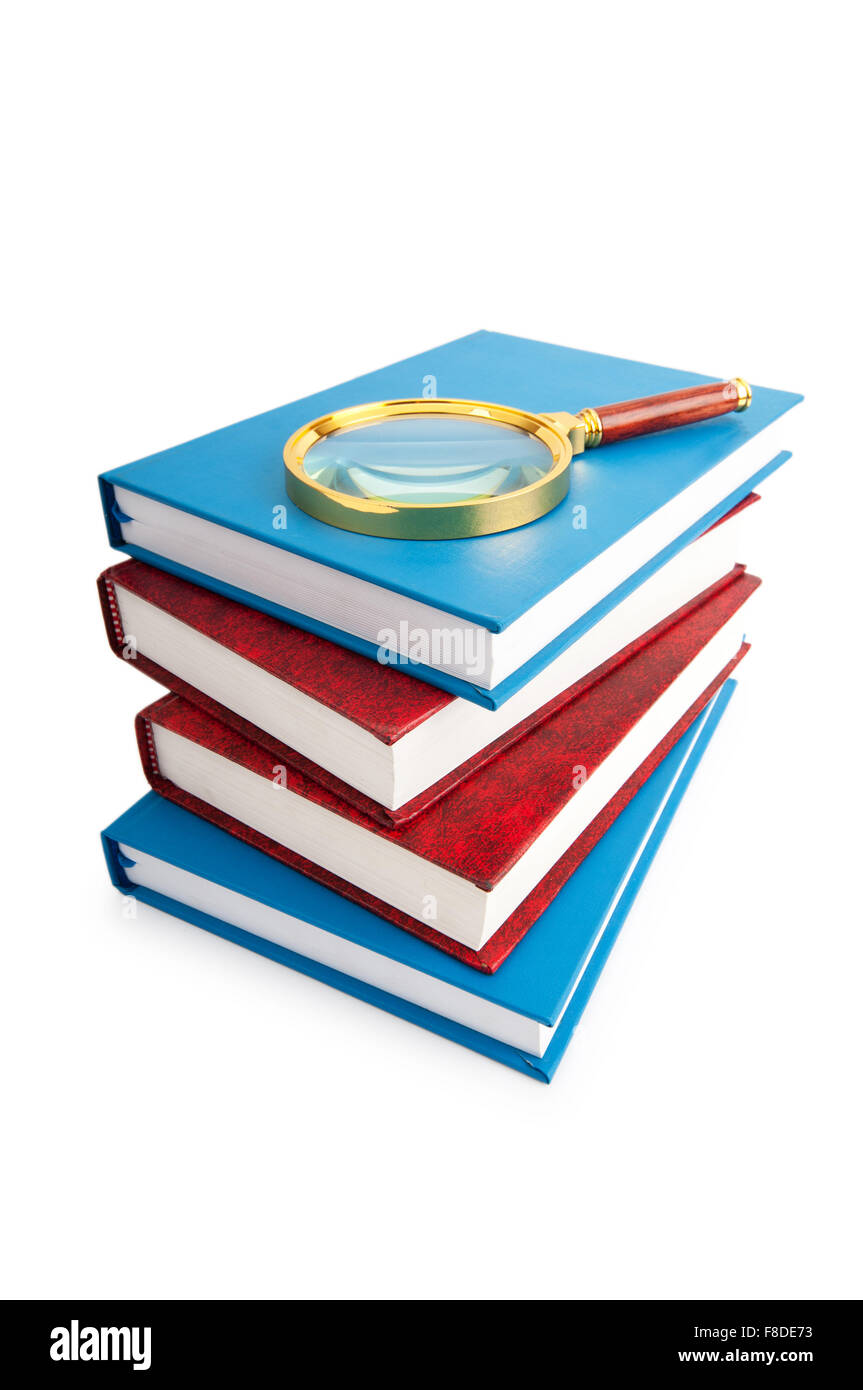 Magnifying glass over the stack of books Stock Photo - Alamy