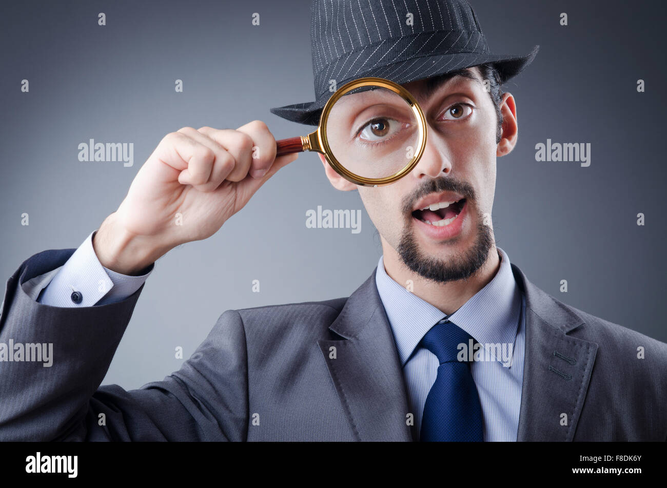 Detective and magnifying glass Stock Photo - Alamy