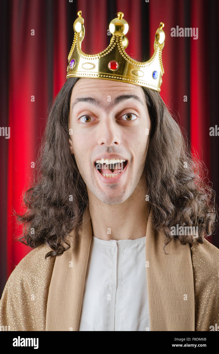 Funny king against red curtain Stock Photo - Alamy