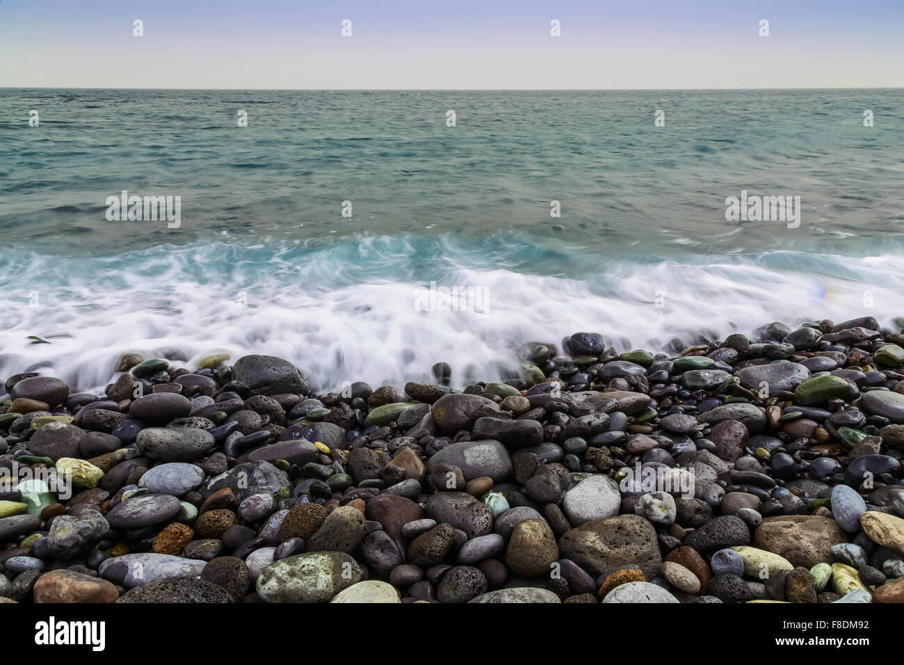 Stone Shore of Ocean with Silky Waves and Foam from long exposure on ...