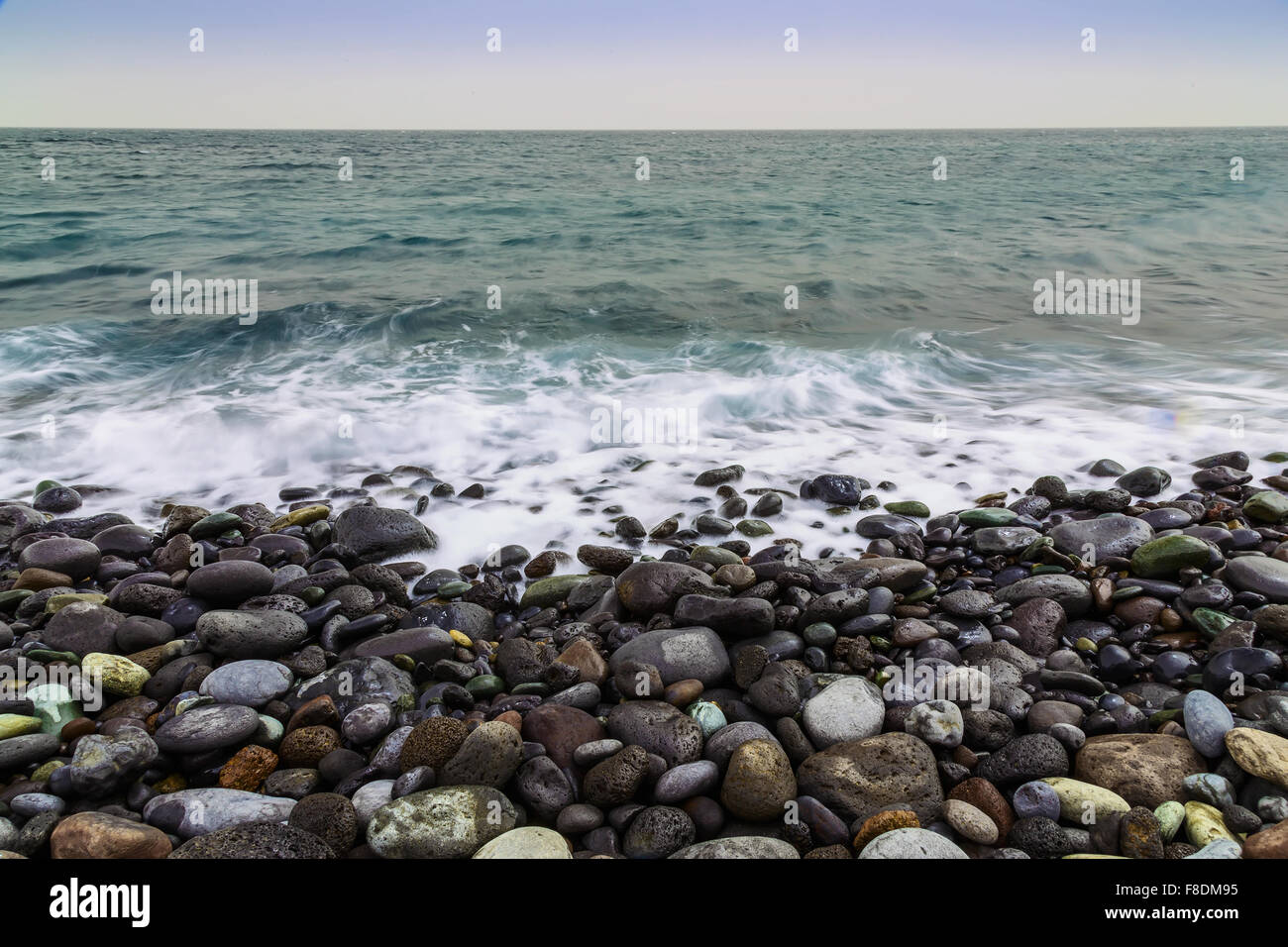 Stone Shore of Ocean with Silky Waves and Foam from long exposure on ...