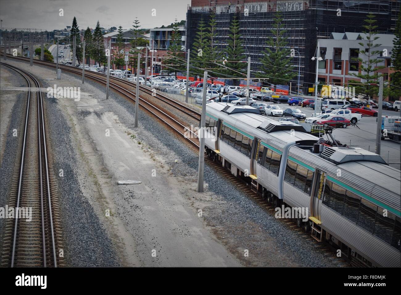 Train carriage travelling along railway lines, car park and buildings ...