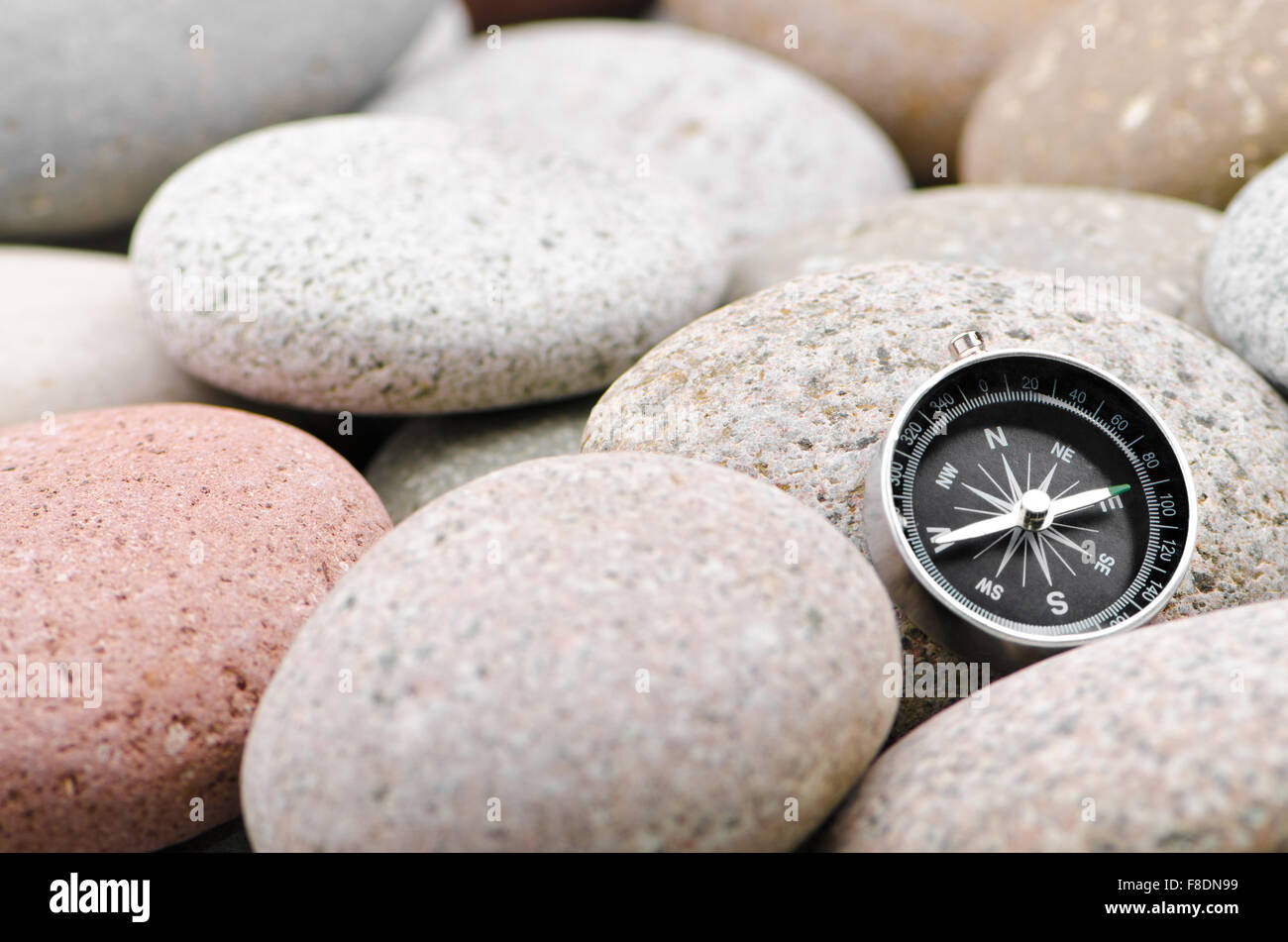 Navigation compass on stone pebbles Stock Photo - Alamy