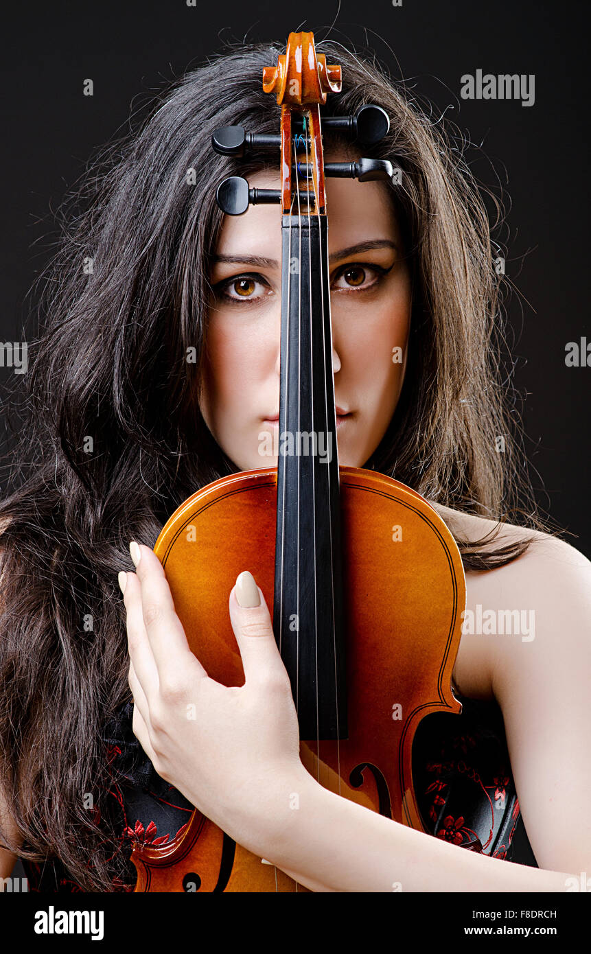 Female violin player against background Stock Photo - Alamy