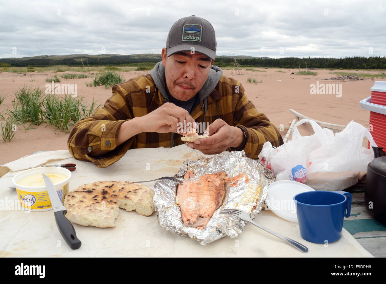 An Innu First Nation man digs into some salmon and bannock in the town ...