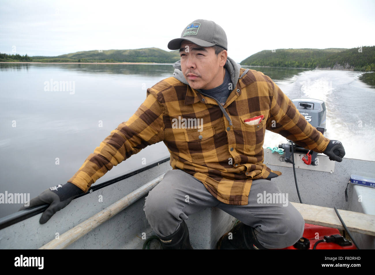 An Innu First Nation man in a motor boat on the St. Augustine river ...