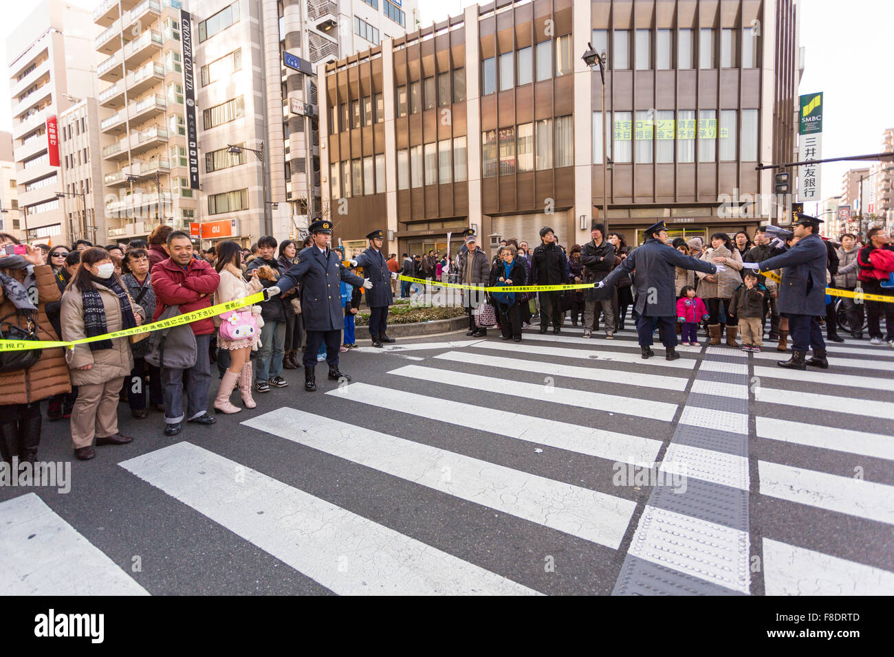 Police holding yellow string to maintain people at their position Stock ...